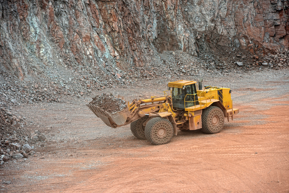 Earth mover loading rocks in a quarry. mining industry. Stock Photo by ...