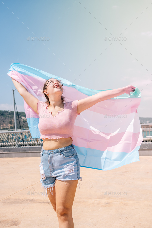 transsexual woman with trans flag, holding a transgender pride flag ...