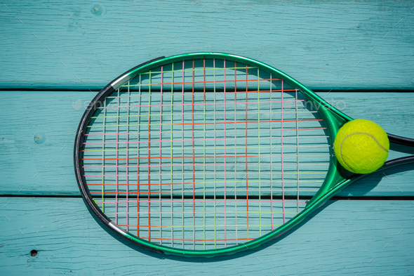 A tennis racket with tennis ball on green wood texture Stock Photo by ...