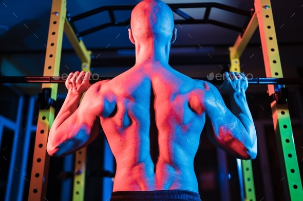 Back view of bodybuilder doing heavy weight workout for back muscles ...