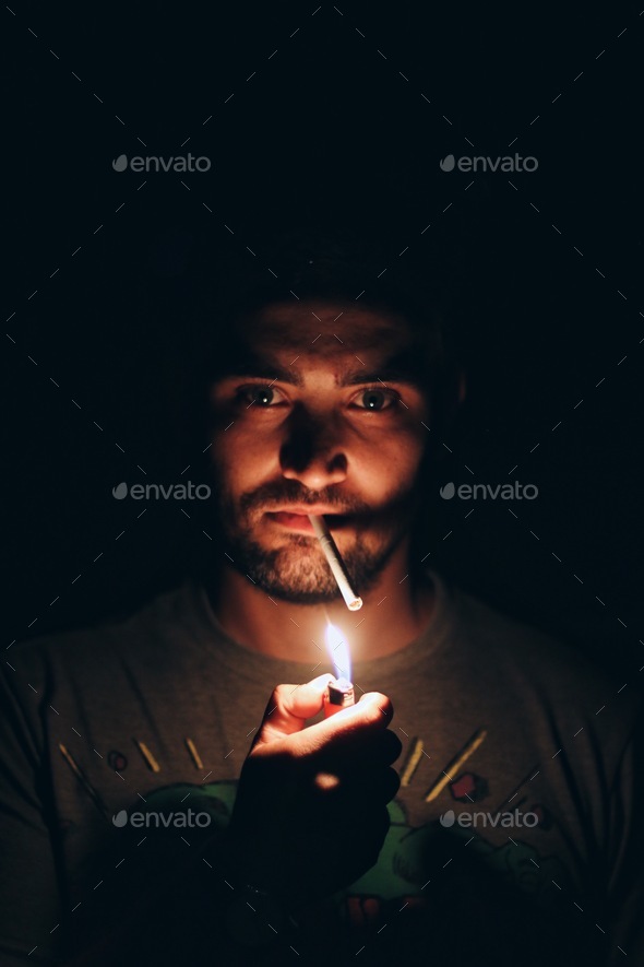 Man lighting up a cigaret in the dark Stock Photo by rademeyerdaniel