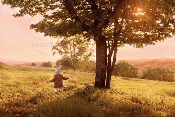 Tiny Humans Big World. The child is standing near a large tree. Stock ...