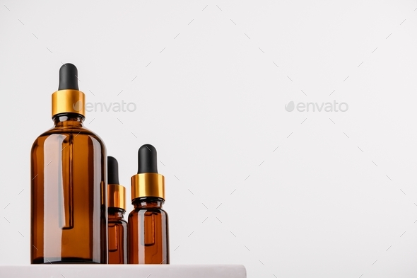 Set of brown glass bottles with essential oil on a white background on ...