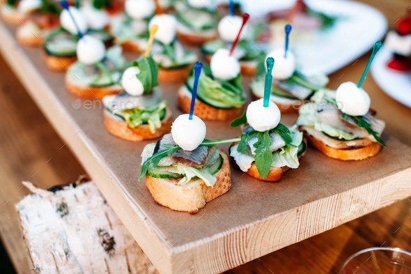 Catering buffet table with fish different sandwiches. Greenery ...