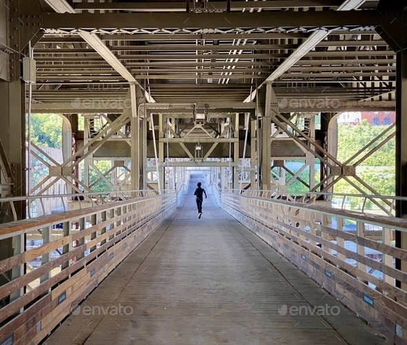 Boy running down the center of a covered bridge... Stock Photo by wendyp23