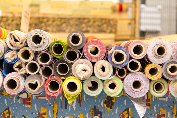Stack of fabrics rolls on a market with pastel colors in the city of ...