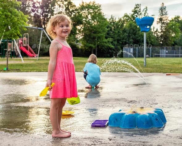 Little children playing at splash pad in the park. Playground with ...