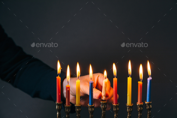 Jewish Holiday Hanukkah concept. Man lighting candles for Hannukah ...