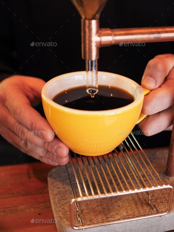 man making coffee in a drip coffee maker using a yellow mug Stock Photo ...