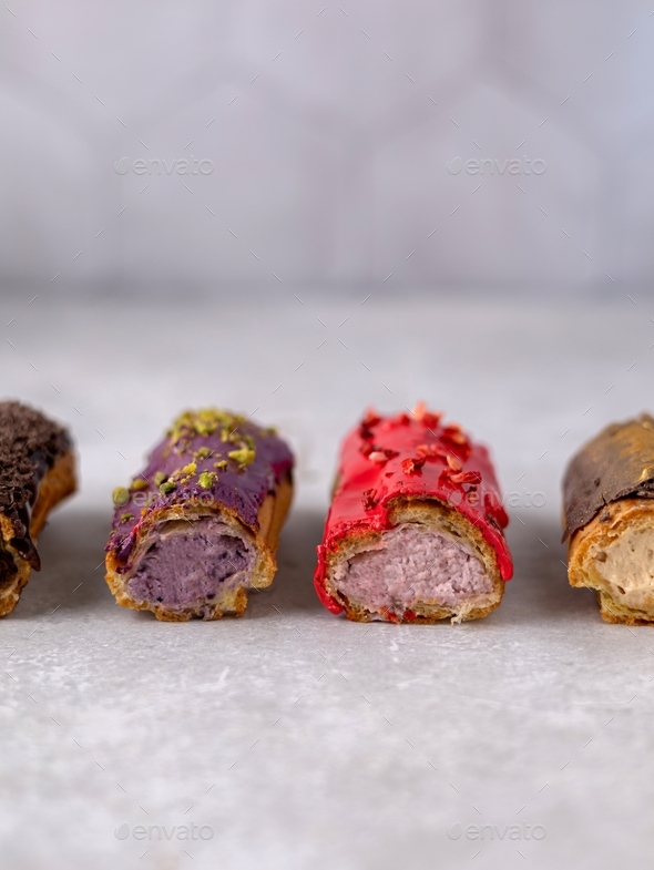 Colorful cut eclairs with different fillings laying on the table Stock ...