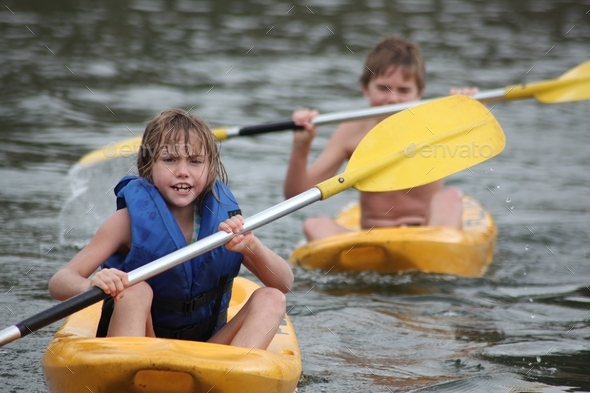 Two children paddling on paddle boards in a lake Stock Photo by ...