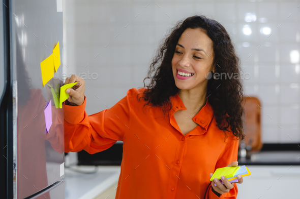 Young and organized female with curly hair in casual clothing making to ...