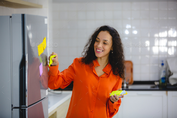 Young and organized female with curly hair in casual clothing making to ...