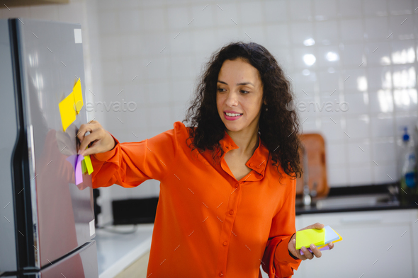 Young and organized female with curly hair in casual clothing making to ...