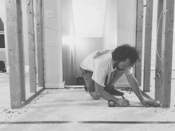 man drawing a line on the floor in a house being built. Stock Photo by ...