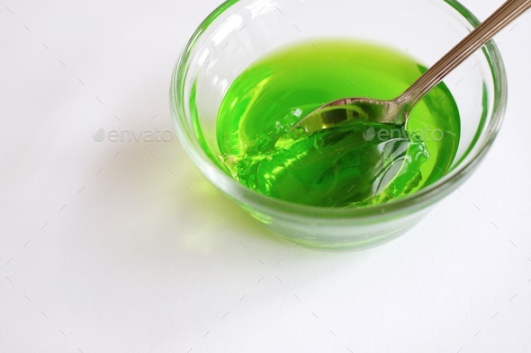 Close up picture of green jello with a spoon Stock Photo by umuller