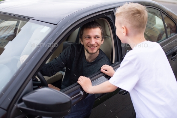 A cute child accompanies a happy father to work. Dad is sitting in the ...
