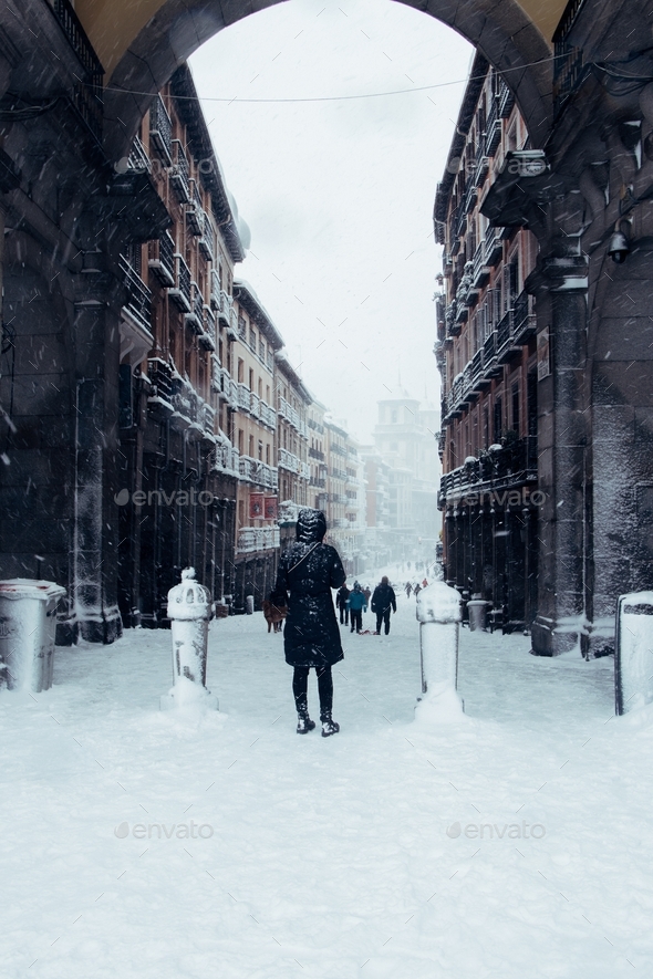 Frozen street. Bright light. Snowfall. Winter. People from behind ...