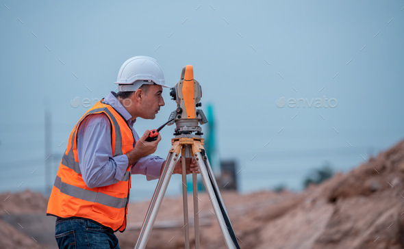Surveyor engineers wearing safety uniform ,helmet and radio ...