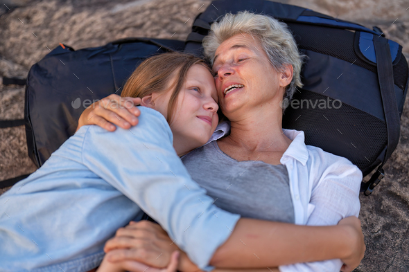 Backpack adventure hiking traveler mother and daughter laying hug on ...
