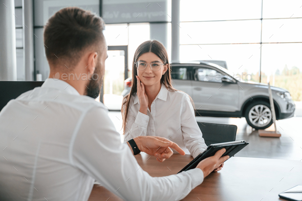 Cheerful customer is smiling. Man with woman in white clothes are in ...