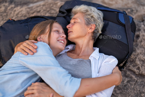 Backpack adventure hiking traveler mother and daughter laying hug on ...