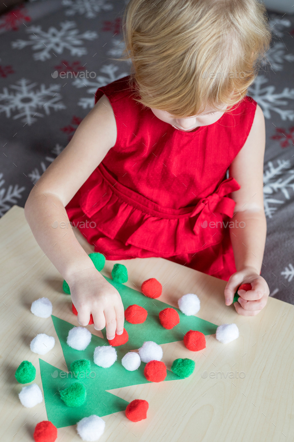 Christmas kids craft activities at home. Little girl playing decorating ...