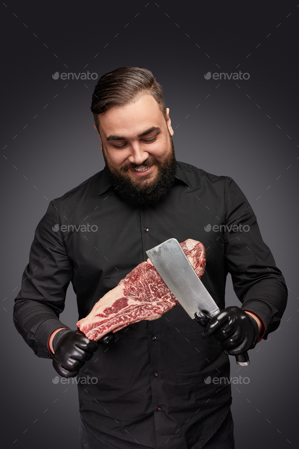 Smiling butcher scratching meat with knife Stock Photo by kegfire ...