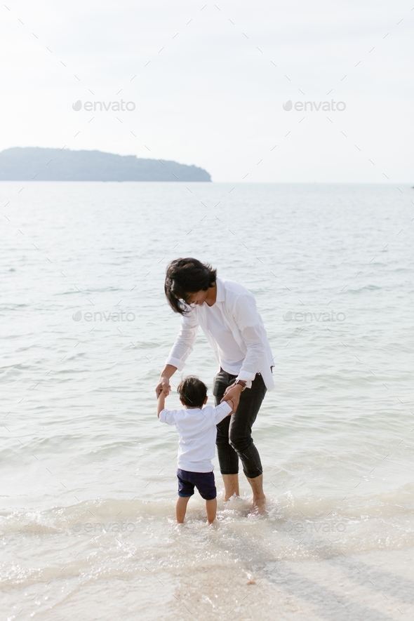 the father play with his boy at the beach Stock Photo by danielhalis