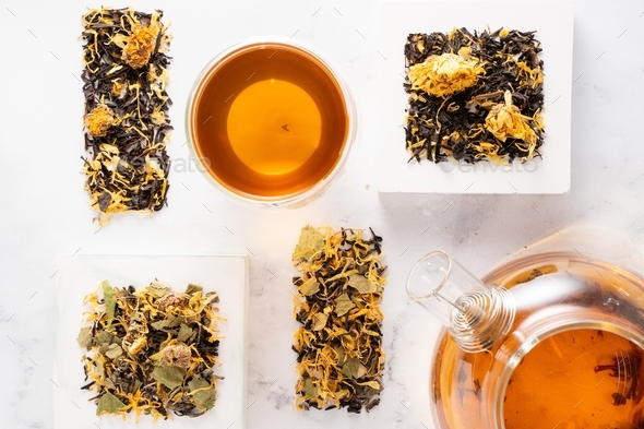 Cup of Home herbal tea. and hot glass teapot with calendula flowers On ...