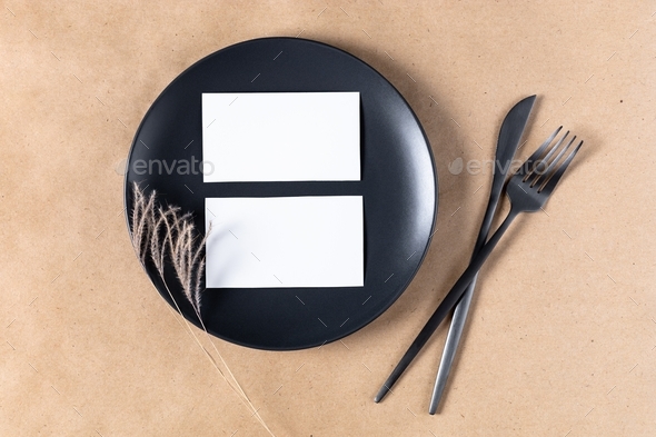 Blank white paper card on plate for mock up with dried spikelets ...