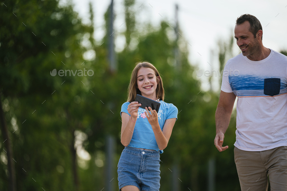 Father handing a smart phone to his little daughter. Stock Photo by ...
