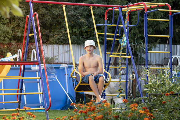 boy teenager swings on a swing at the dacha in summer Stock Photo by ...