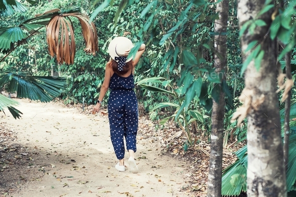 Woman walking in the tropical rainforest, back view Stock Photo by marowl