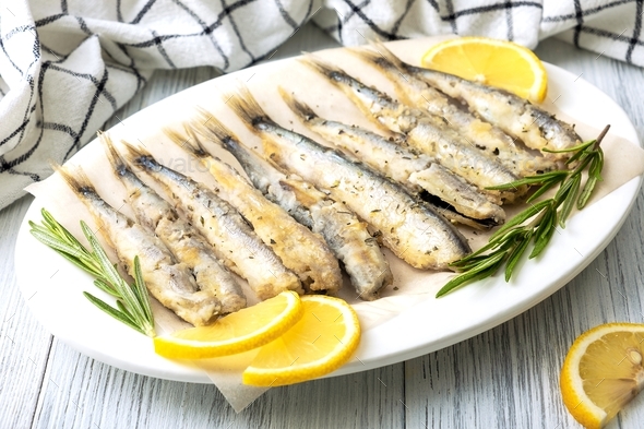 Fried capelin on a white porcelain dish Stock Photo by OlgaGubskaya