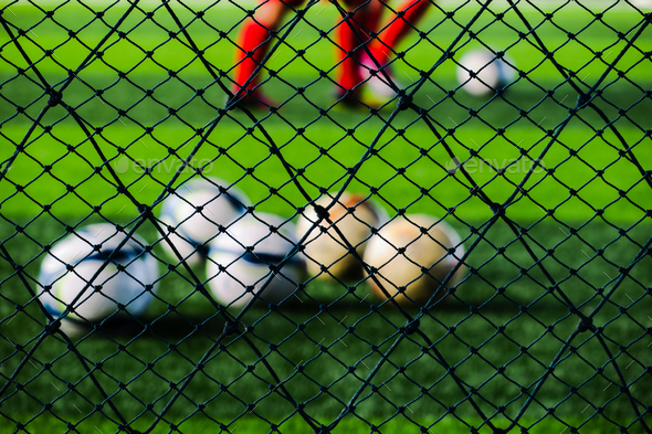 Blurry soccer ball on green field in sports stadium blur football team ...