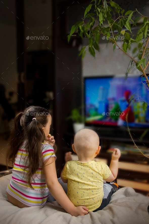 Older sister and little brother watch cartoons on TV. Stock Photo by ...