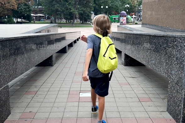 Back to school Happy blonde boy pupil with green backpack goes home ...