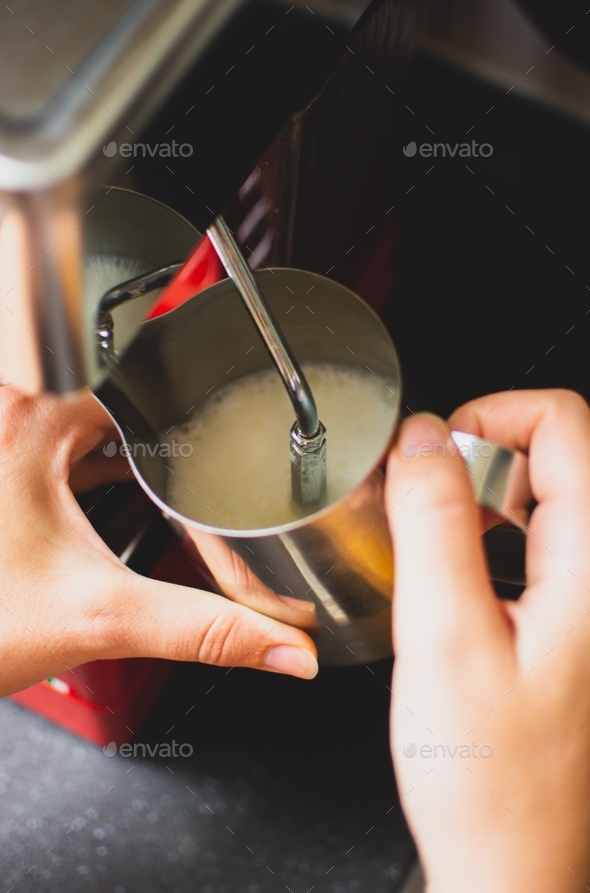 Frothy milk from an espresso machine coffee maker at home barista ...