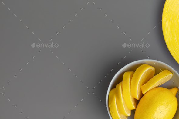 Yellow lemons in gray plate. Colors of the Year 2021 Pantone ...