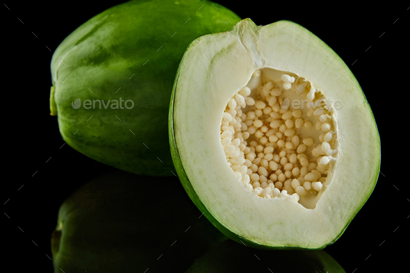 Green round papaya on a black background with reflection Stock Photo by ...