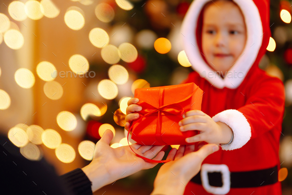 Christmas gift in the hands of a child. Cute little boy receiving ...