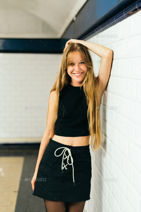 Blonde woman leaning down a white brick wall Stock Photo by kikea3