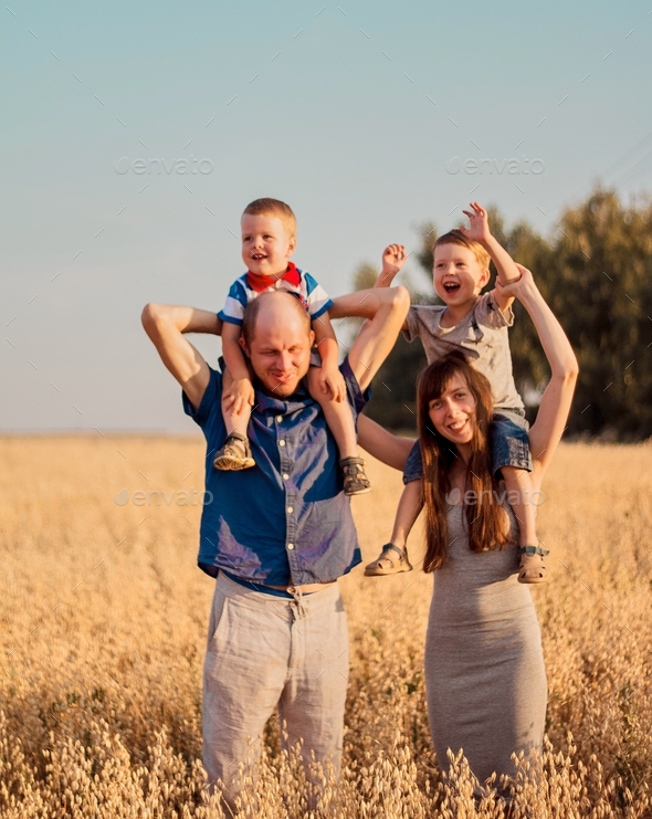 happy married couple with two children. Family in the field at a photo ...