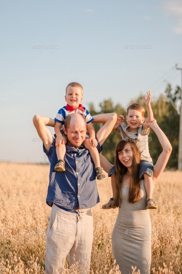 happy married couple with two children. Family in the field at a ...