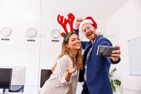 Business people having fun at the office Christmas party, taking ...