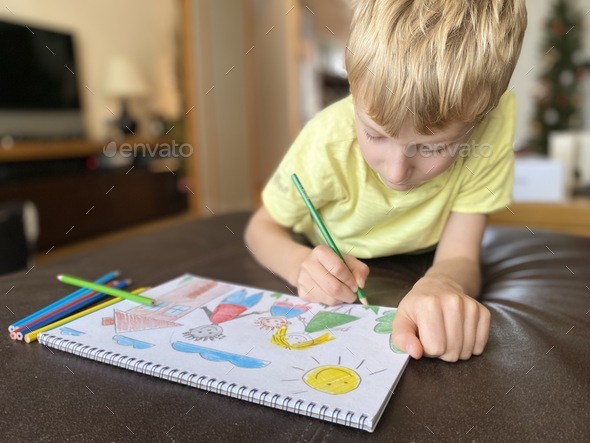 boy draws his family with colored pencils Stock Photo by elenabednykh