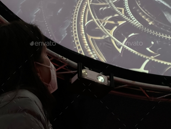 looking up at a video projection of clock parts rotating in an ...