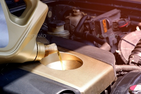 Pouring engine oil into car engine Stock Photo by aowsakornprapat