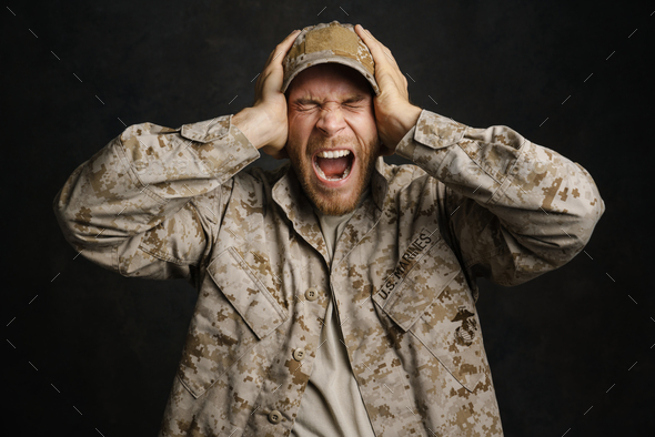 White military man wearing uniform screaming while holding his head ...